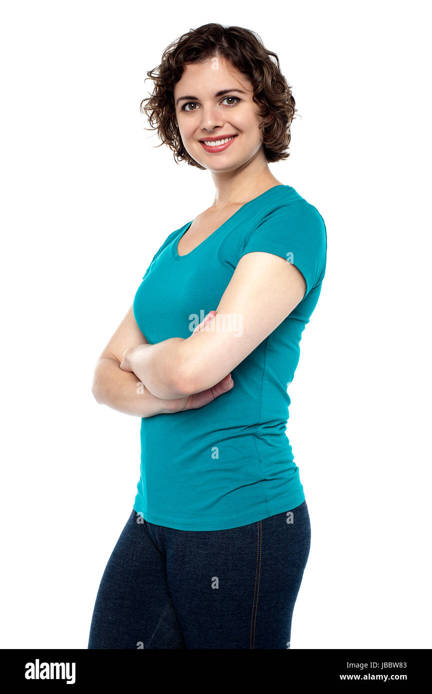 Cheerful young lady on white background posing sideways with her hands ...