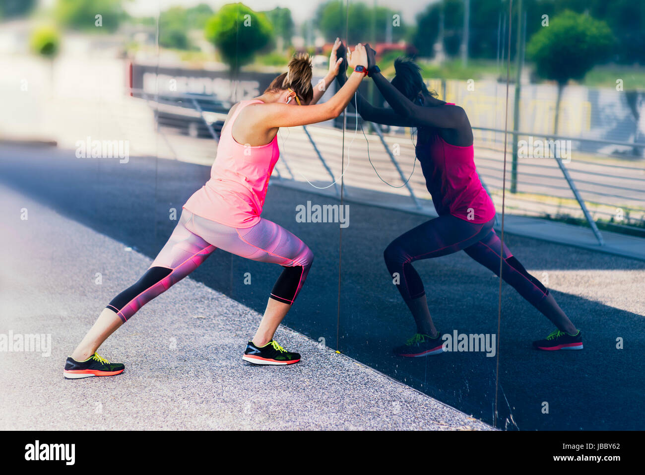 Young woman stretching after high intensity training in an urban ...