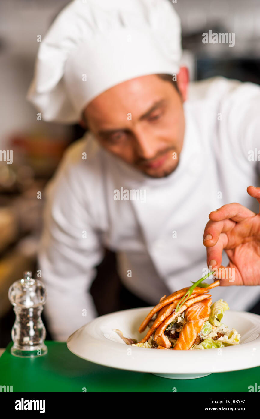 Chef adding final touch to delicious baked salmon Stock Photo - Alamy