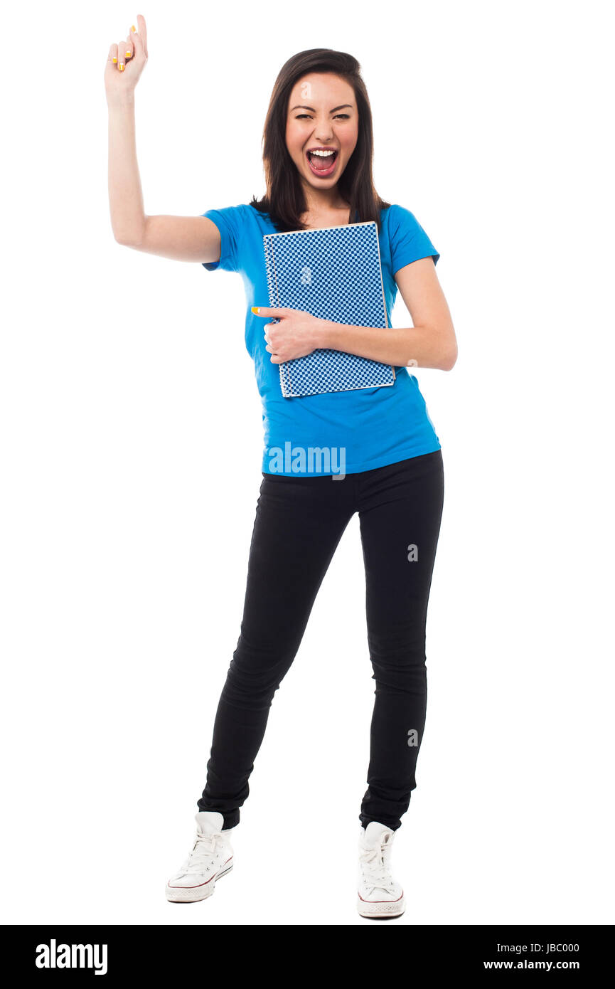 Girl student raising her arm up and holding notebook, extremely excited ...