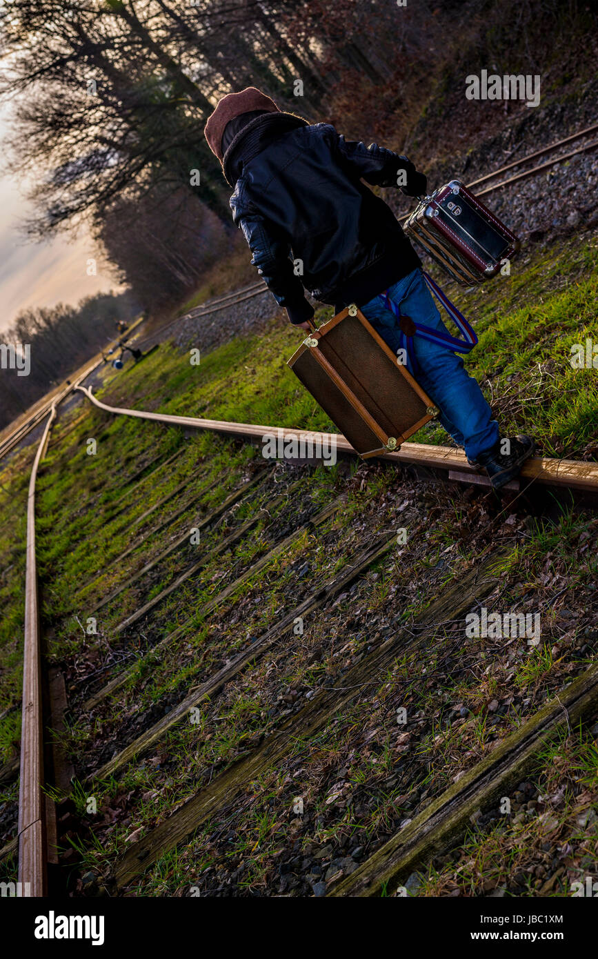 boy with suitcases following train rail to his destination Stock Photo ...