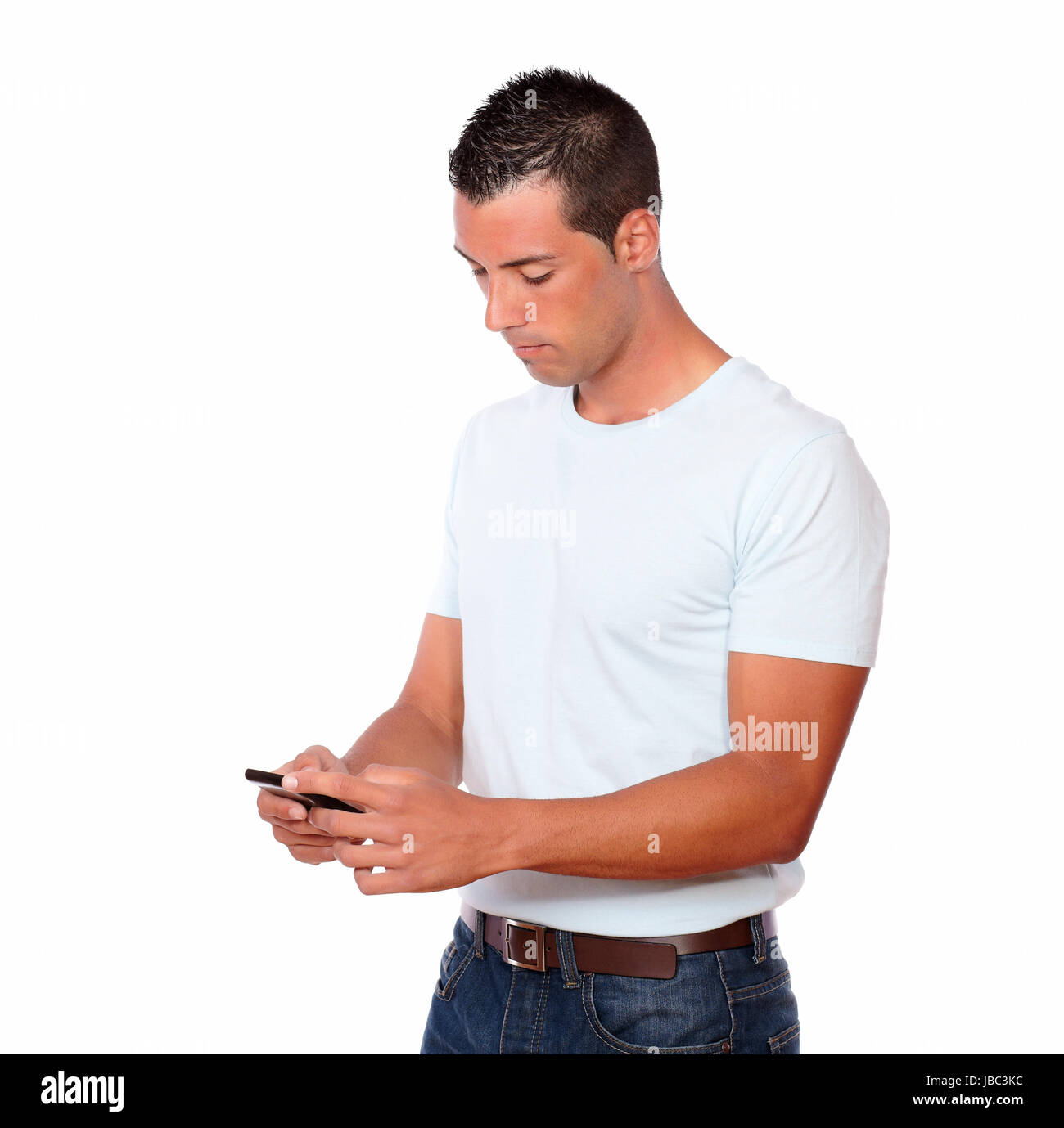 Portrait of a cute hispanic guy sending a message with his cellphone ...