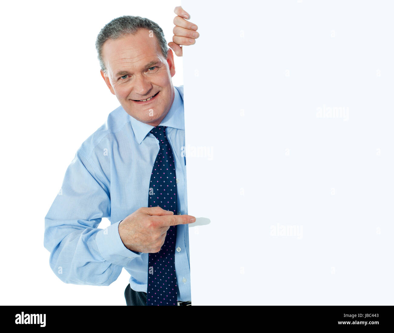 Salesman smiling and pointing towards blank billboard isolated over ...