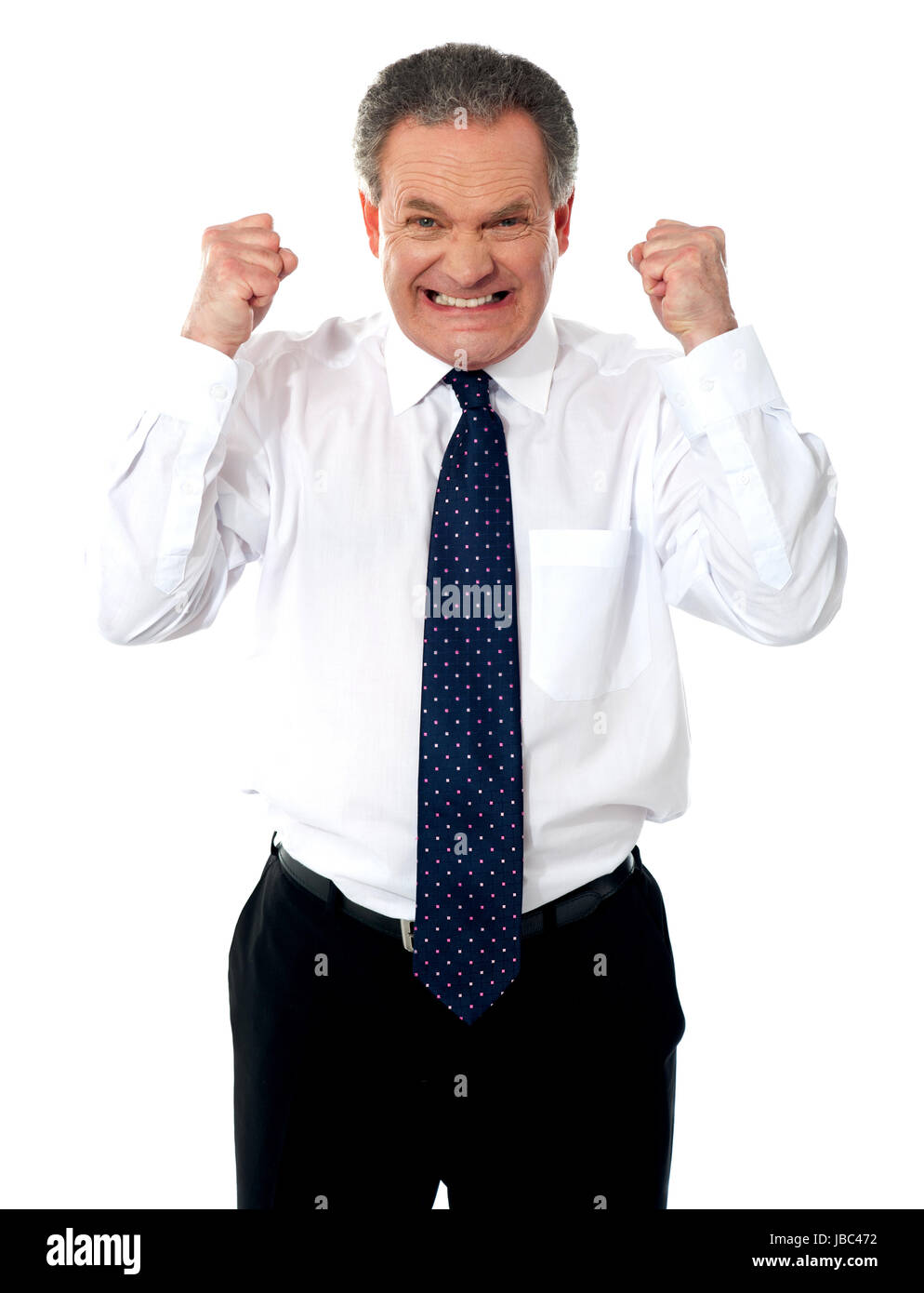 Angry senior corporate man standing with hs fists clenched against ...