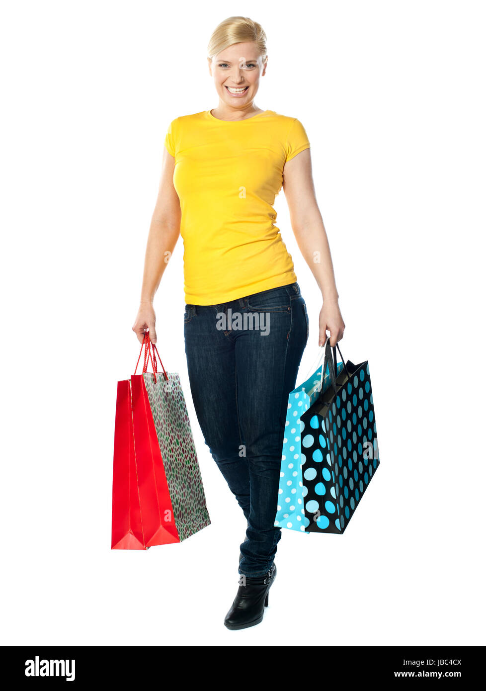 Attractive girl carrying colourful shopping bags, walking pose Stock ...