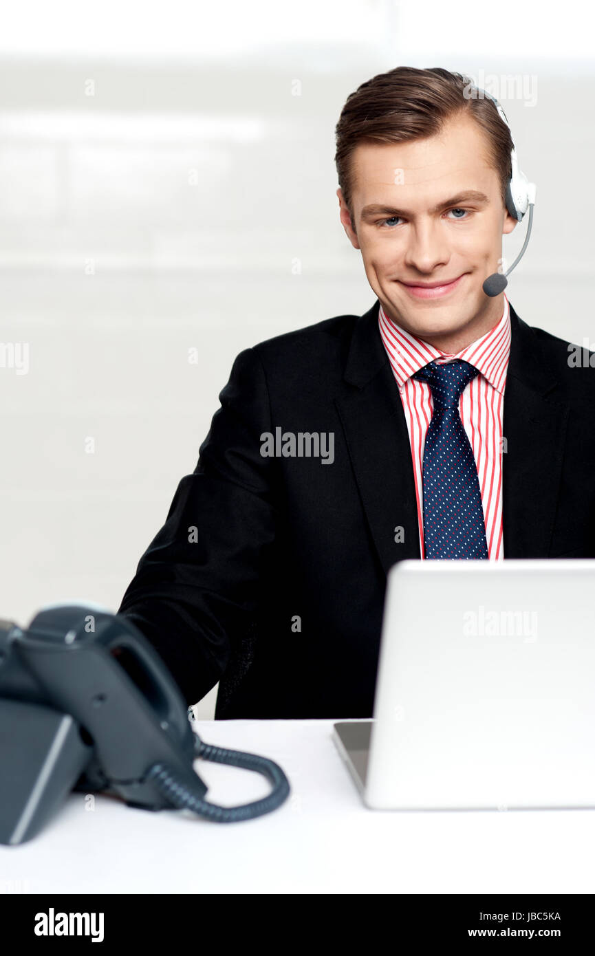 Male executive wearing headsets and smiling. Sitting in office Stock ...