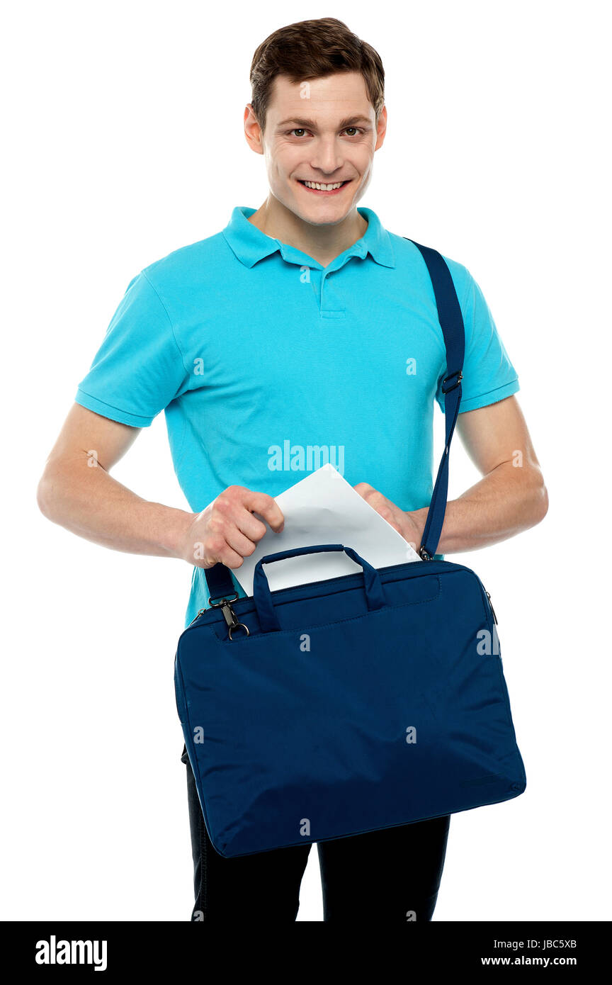 Guy taking out paper from his laptop bag and smiling at camera Stock ...