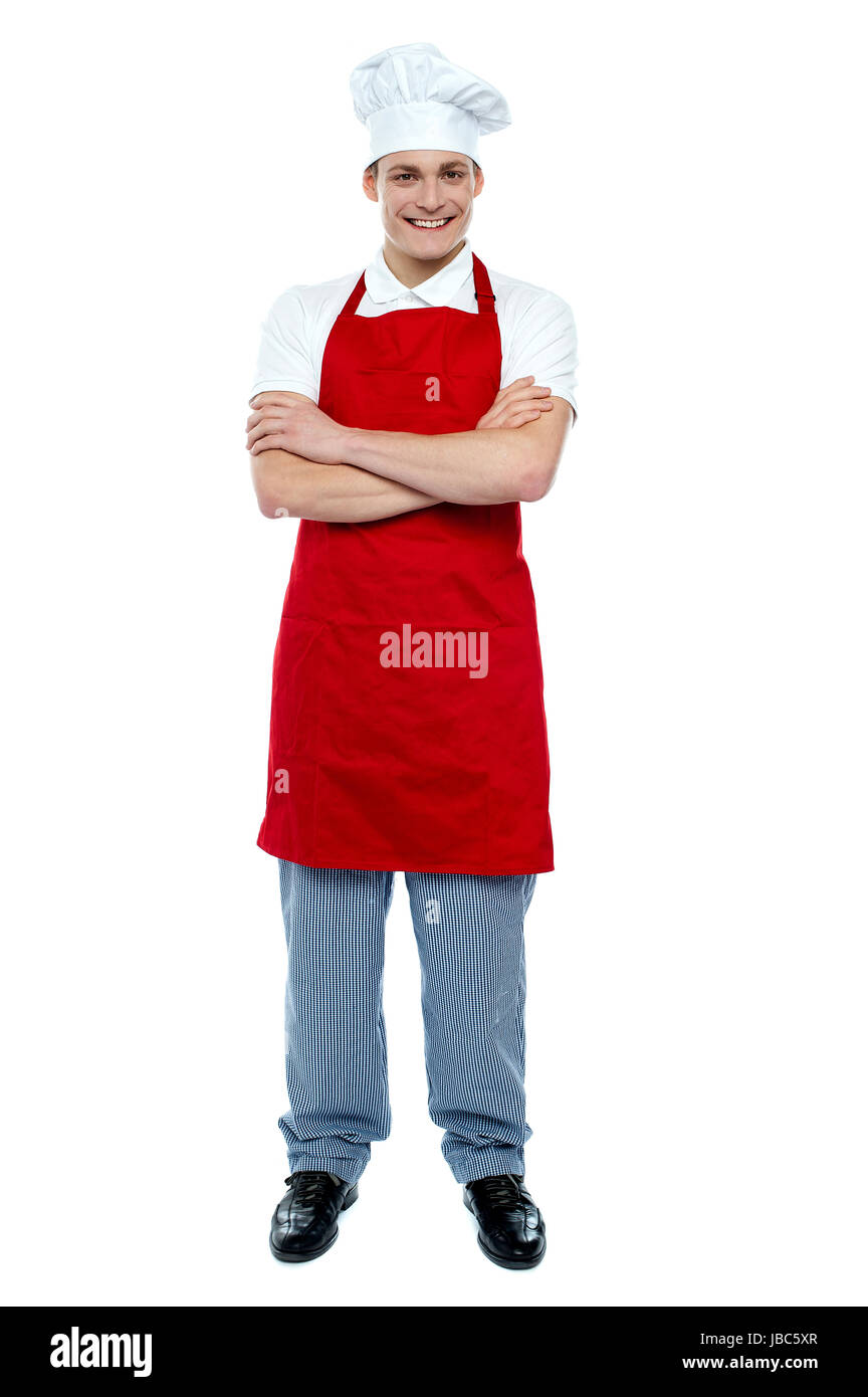 Handsome young cook posing in uniform with arms crossed, full length ...