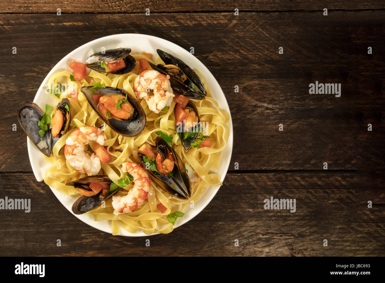A photo of a ready to eat seafood pasta dish with mussels and shrimps ...