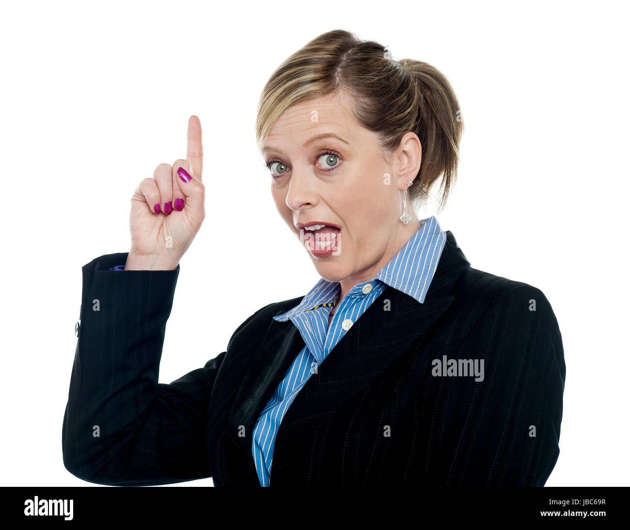 Shocking corporate woman pointing upwards on white background Stock ...