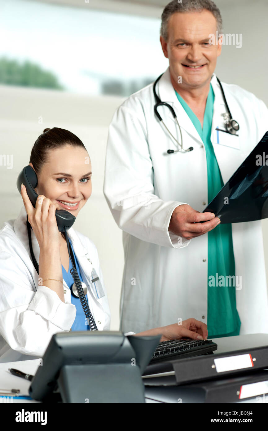 Two medical representatives. Woman attending call and man holding x-ray ...