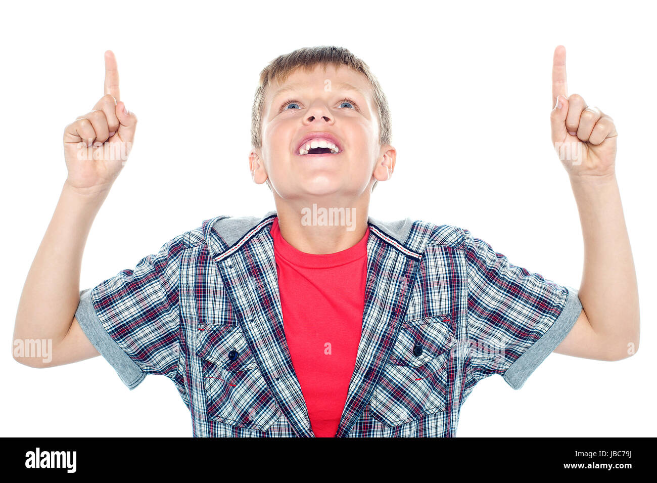 Smiling young child looking up and pointing. All on white background ...
