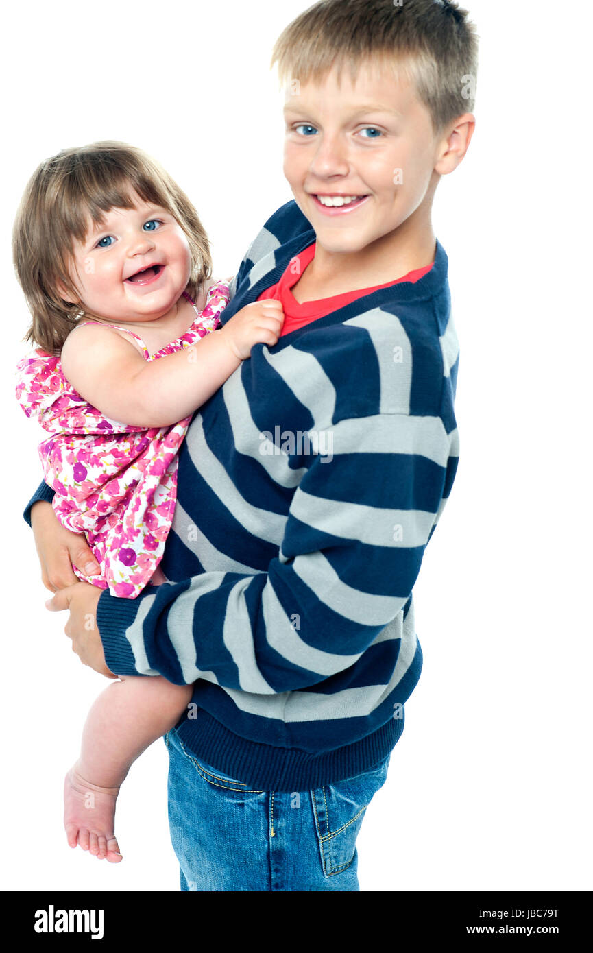 Loving young brother carrying his sweet little toddler sister. Strong ...