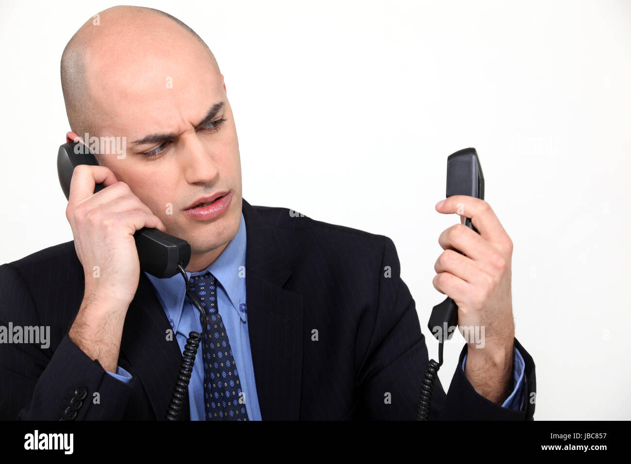 Man with two phones Stock Photo - Alamy