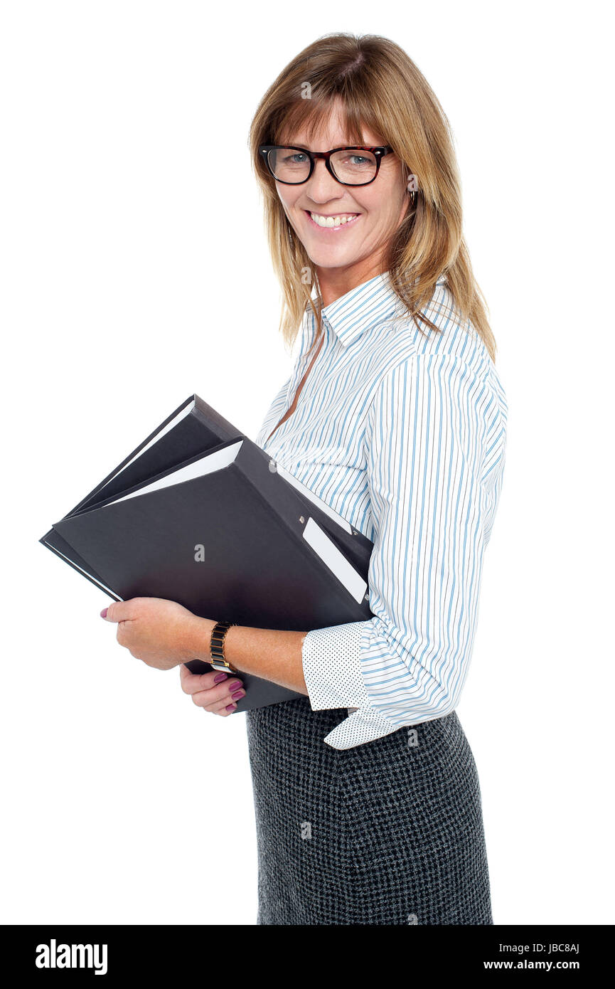 Cheerful female secretary with files in hand smiling at the camera ...
