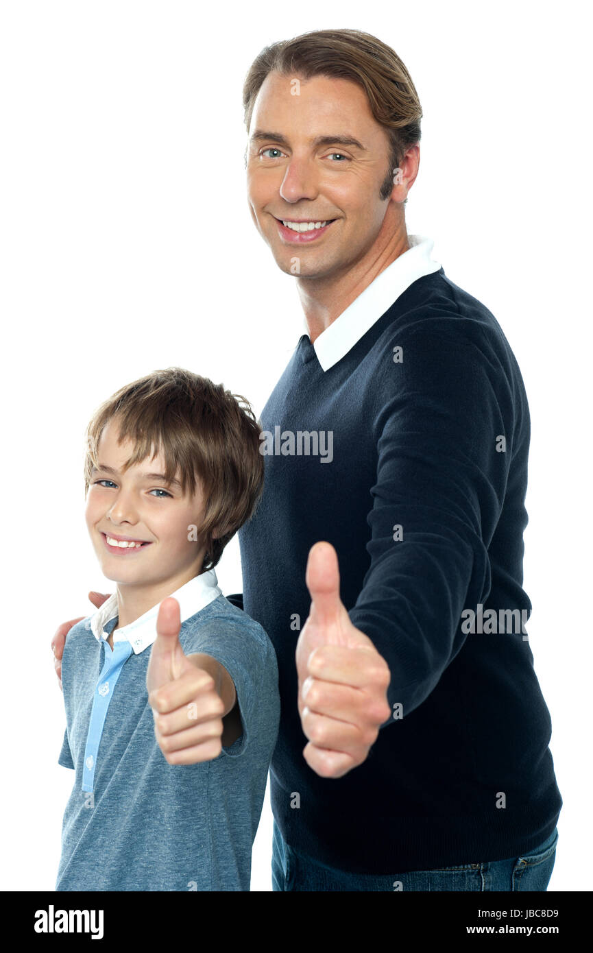 Confident father and son duo gesturing thumbs up sign. Smiling faces ...