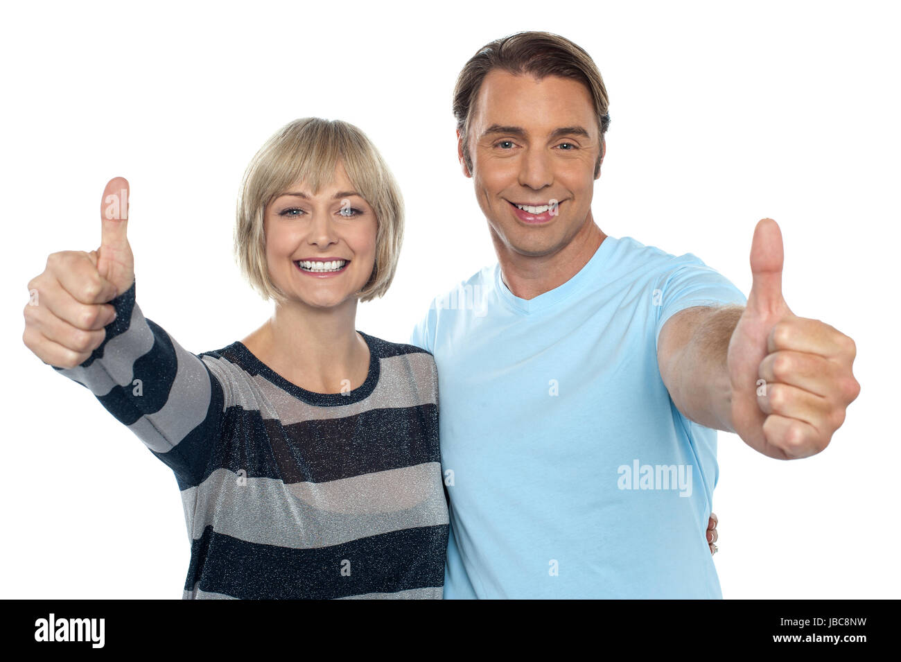 Confident couple showing thumbs up sign to the camera, embracing each ...