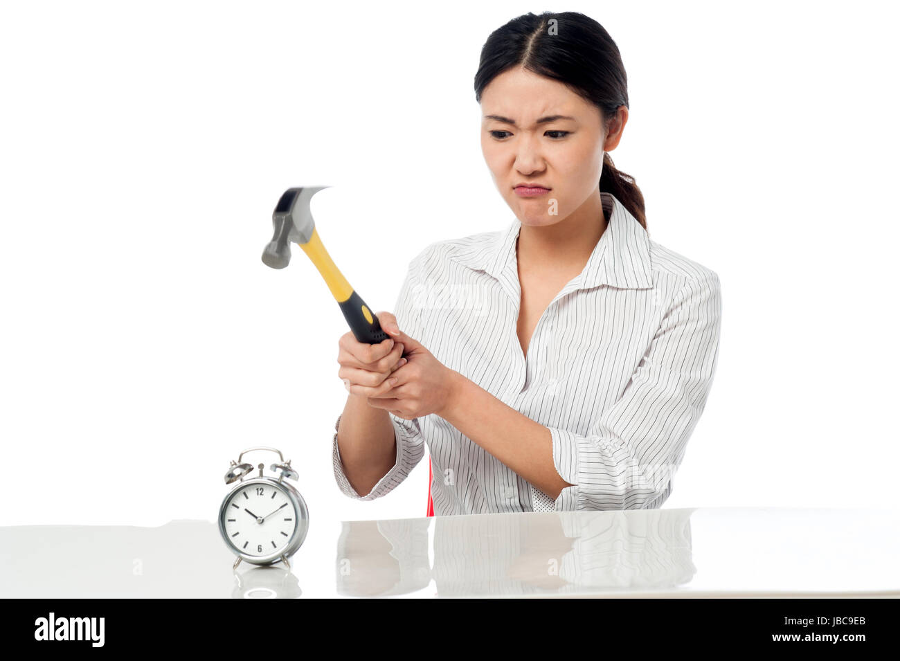 Angry business woman smashing an alarm clock with hammer Stock Photo ...