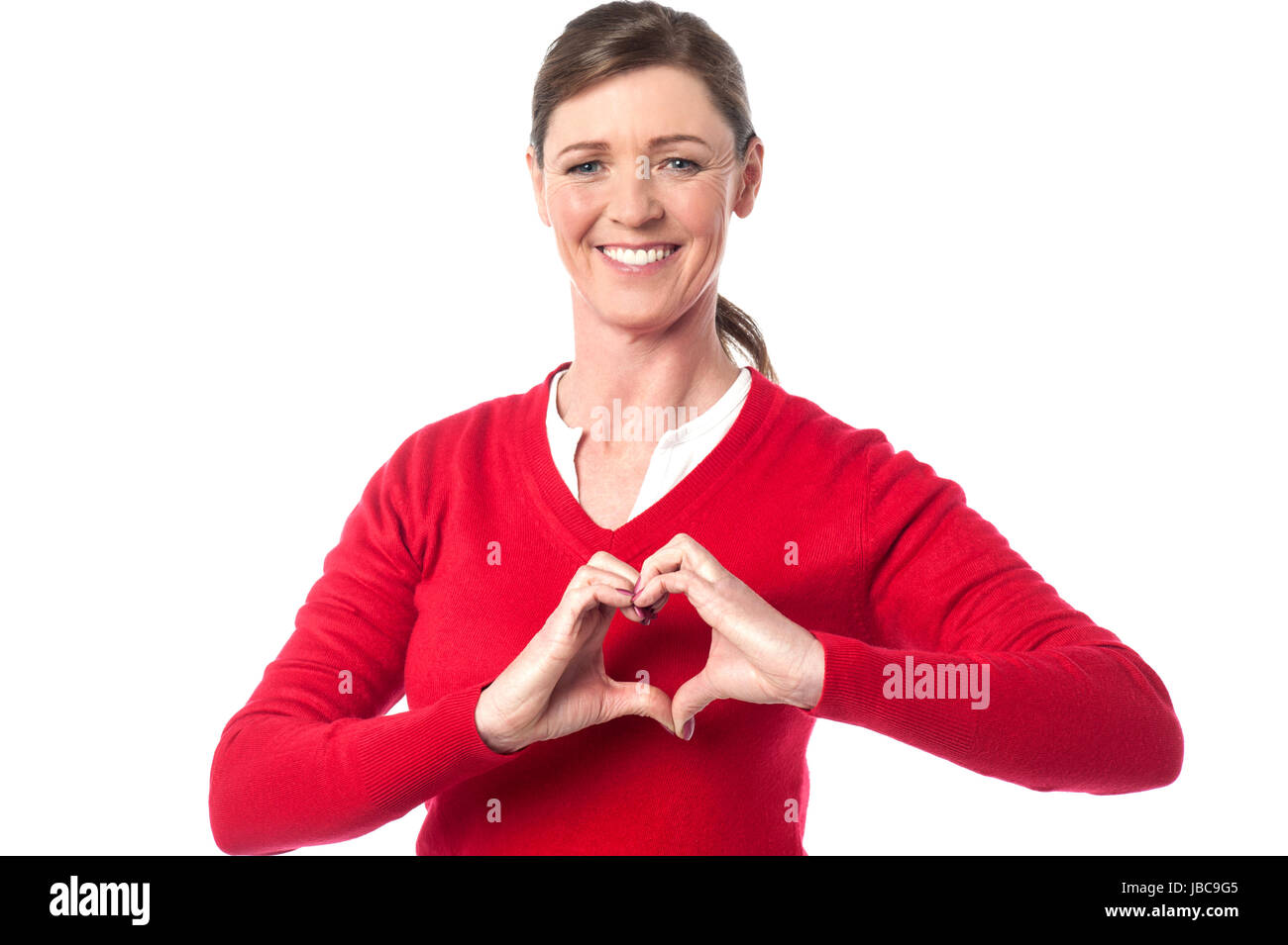 Middle aged woman making heart symbol with her hands Stock Photo - Alamy
