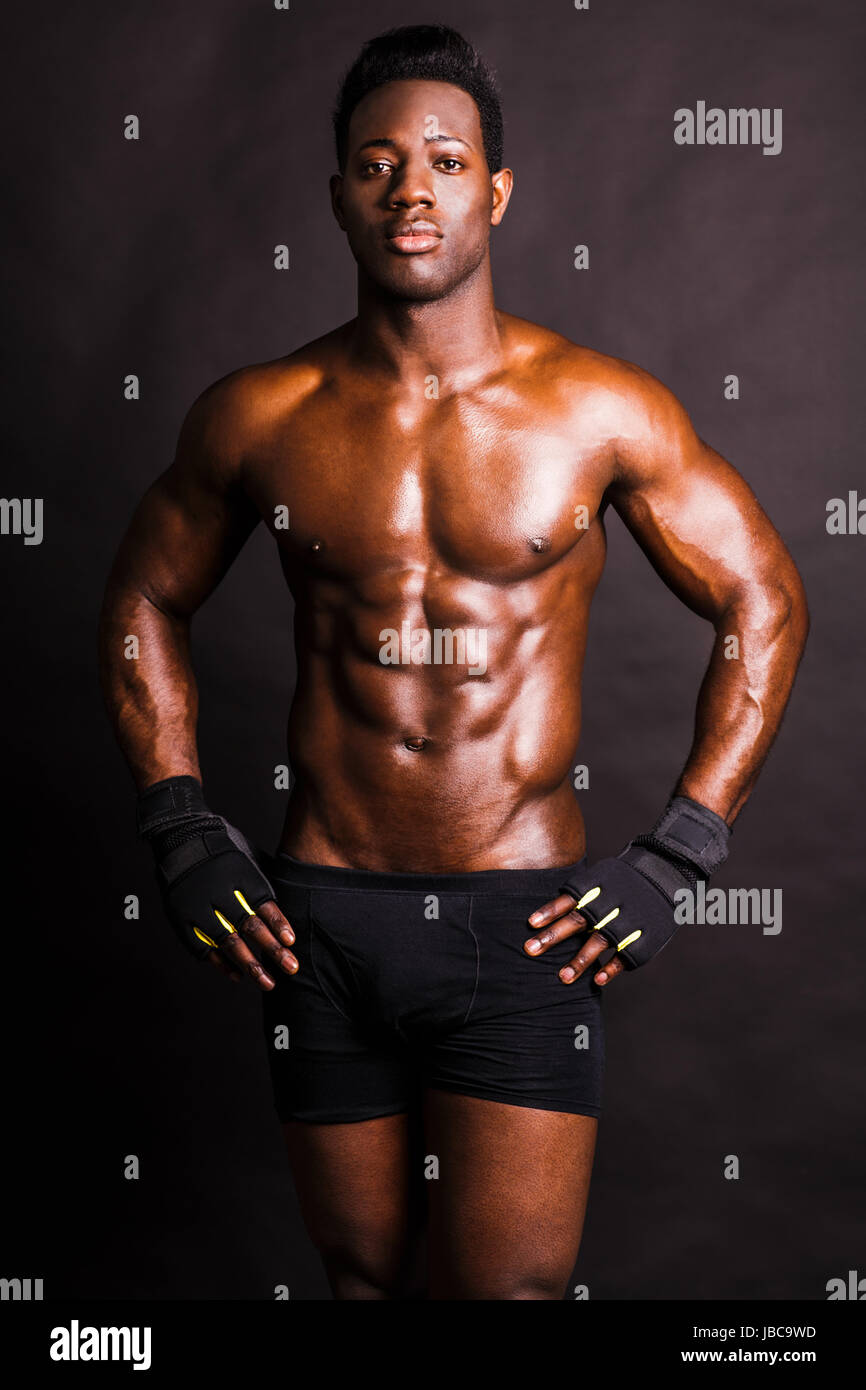 Portrait of muscular african man over black background Stock Photo - Alamy