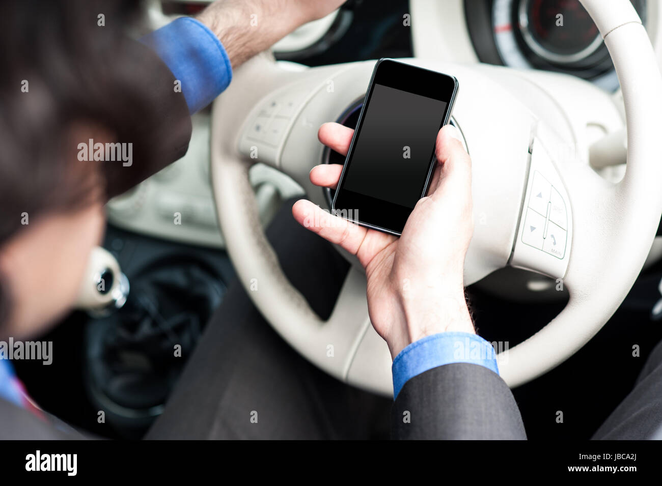 Corporate male using cellphone while driving his car Stock Photo - Alamy