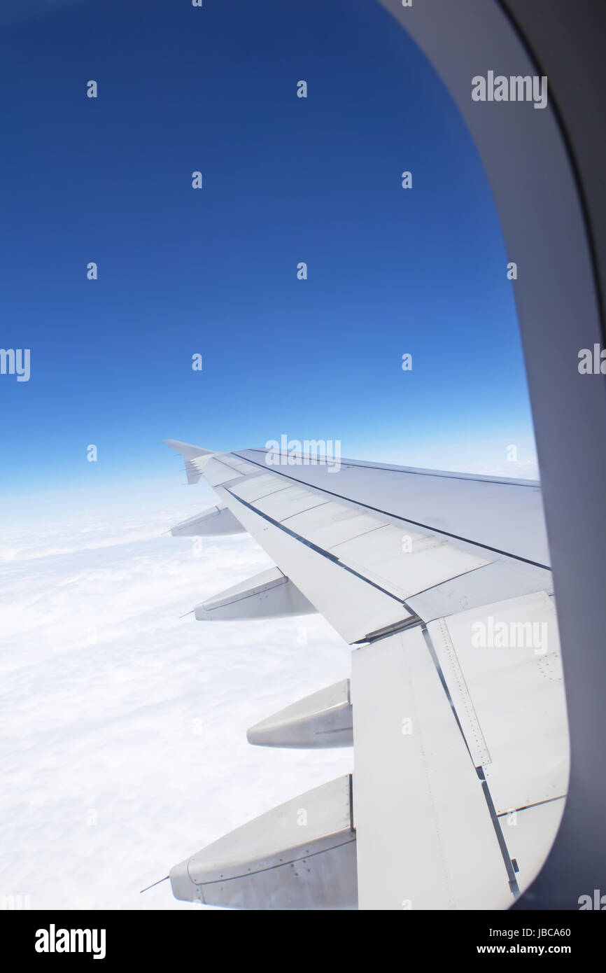 Airplane window looking out over the wing. Vertically Stock Photo - Alamy