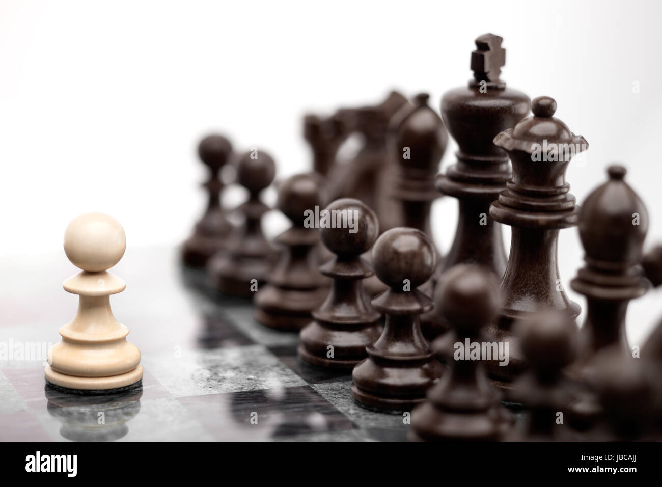 One pawn staying against full set of chess pieces Stock Photo - Alamy
