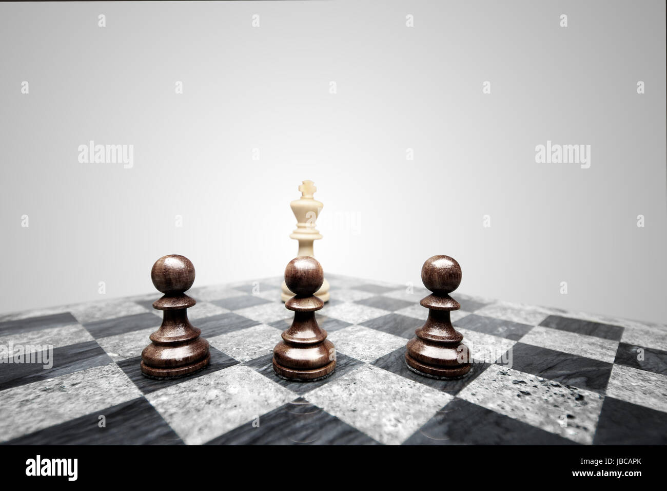 Three pawns in a raw standing in front of king shape Stock Photo - Alamy