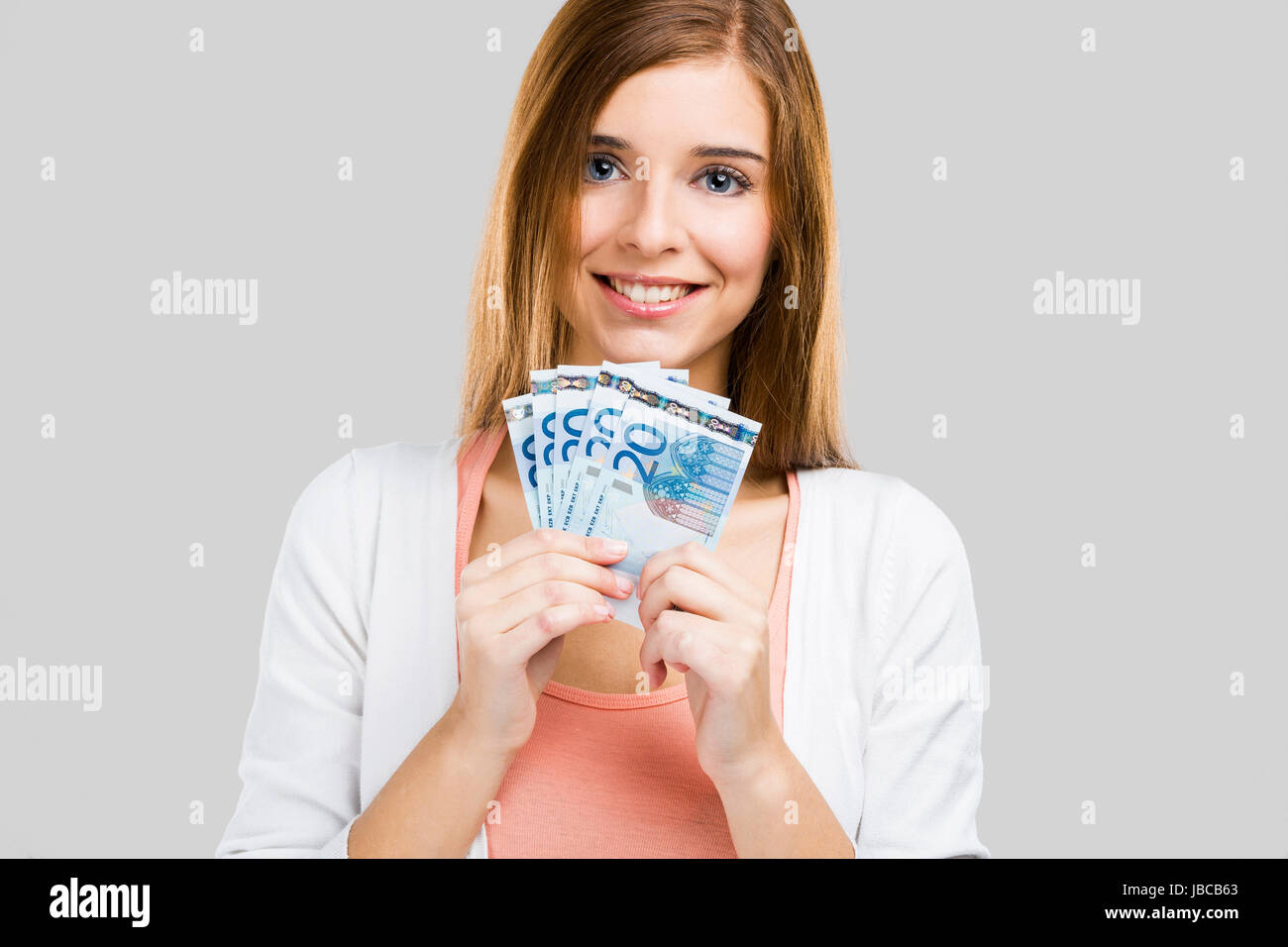 Beautiful and happy woman holding euro currency notes, isolated over ...