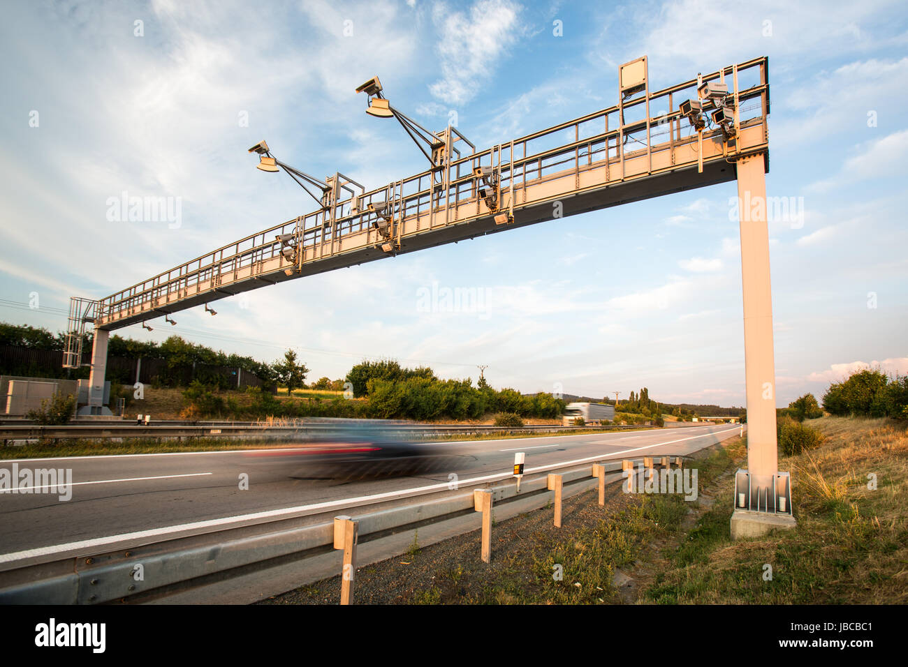 Car passing through a toll gate on a highway (motion blurred image ...