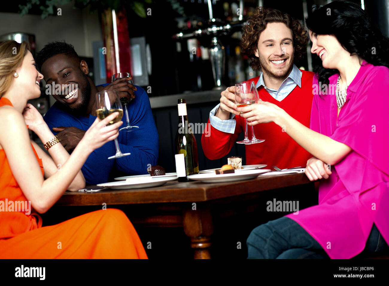 Friends enjoying snacks with drinks in a bar Stock Photo - Alamy