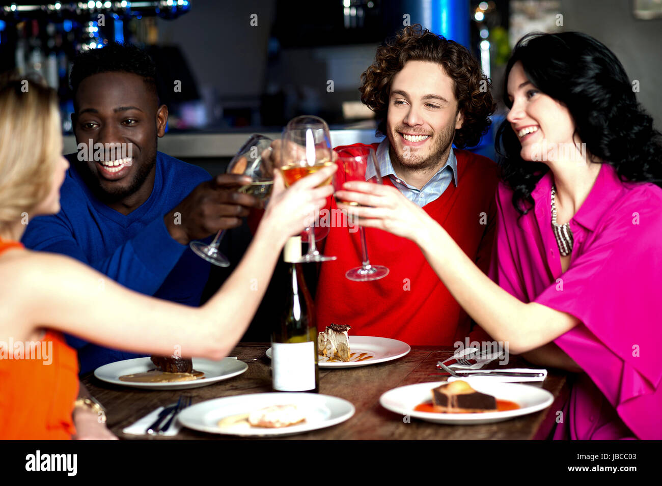 Happy friends talking raising toast hi-res stock photography and images ...