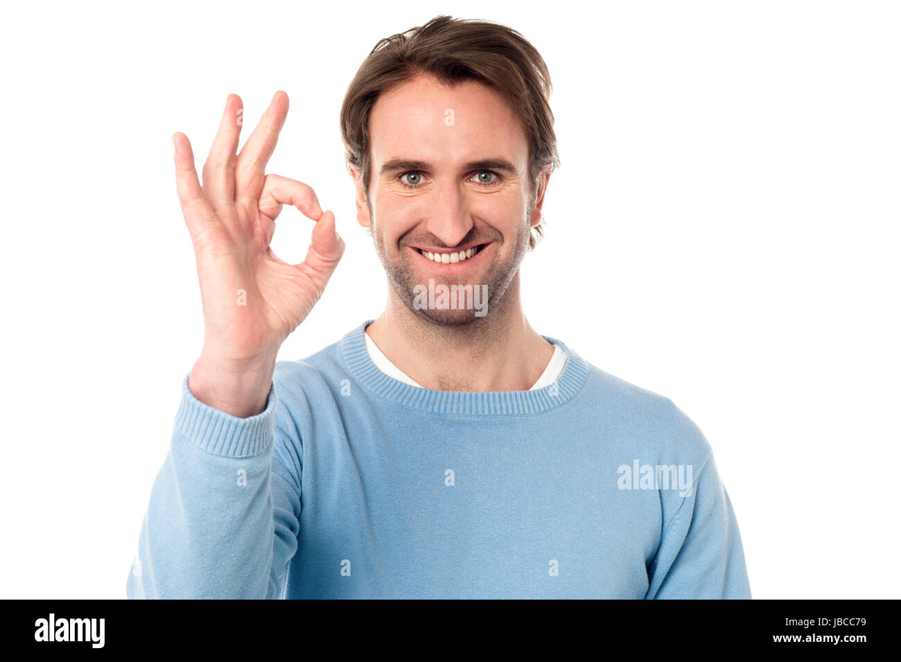 Handsome young man showing OK sign over white Stock Photo - Alamy