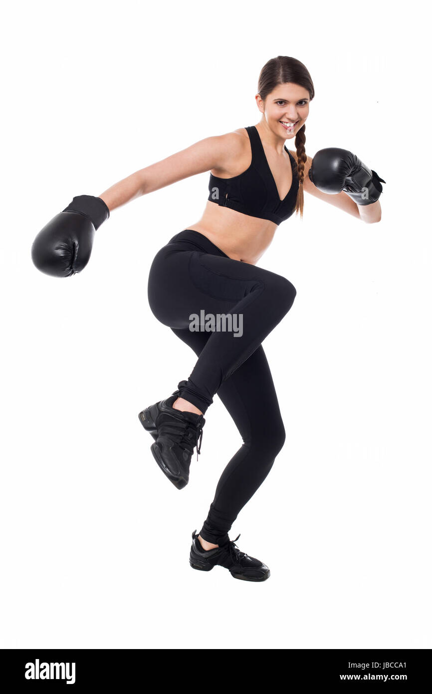 Isolated young female boxer kicking hard Stock Photo - Alamy