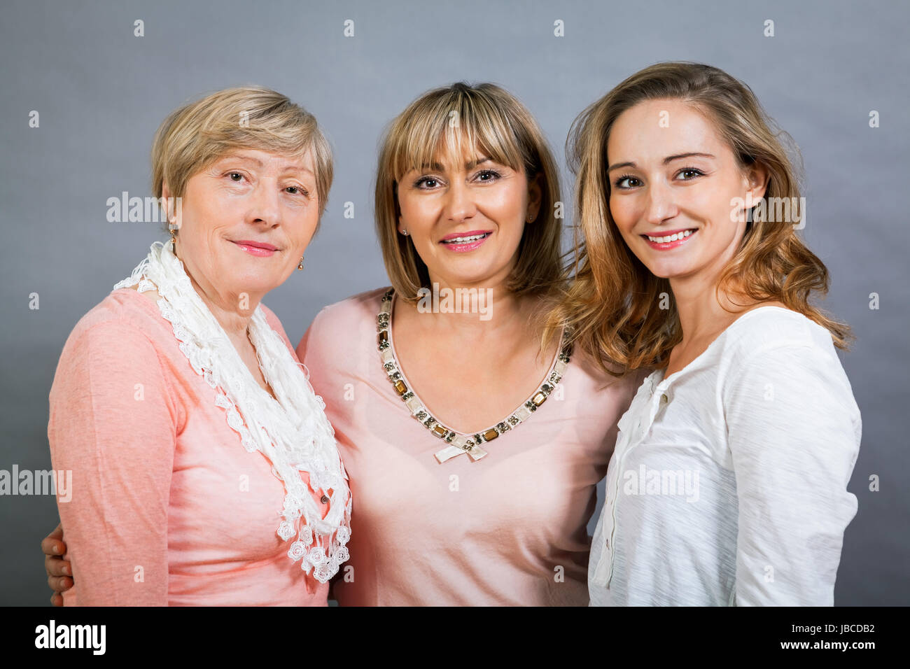 drei generationen großmutter mutter und tochter im portrait vor grauem ...