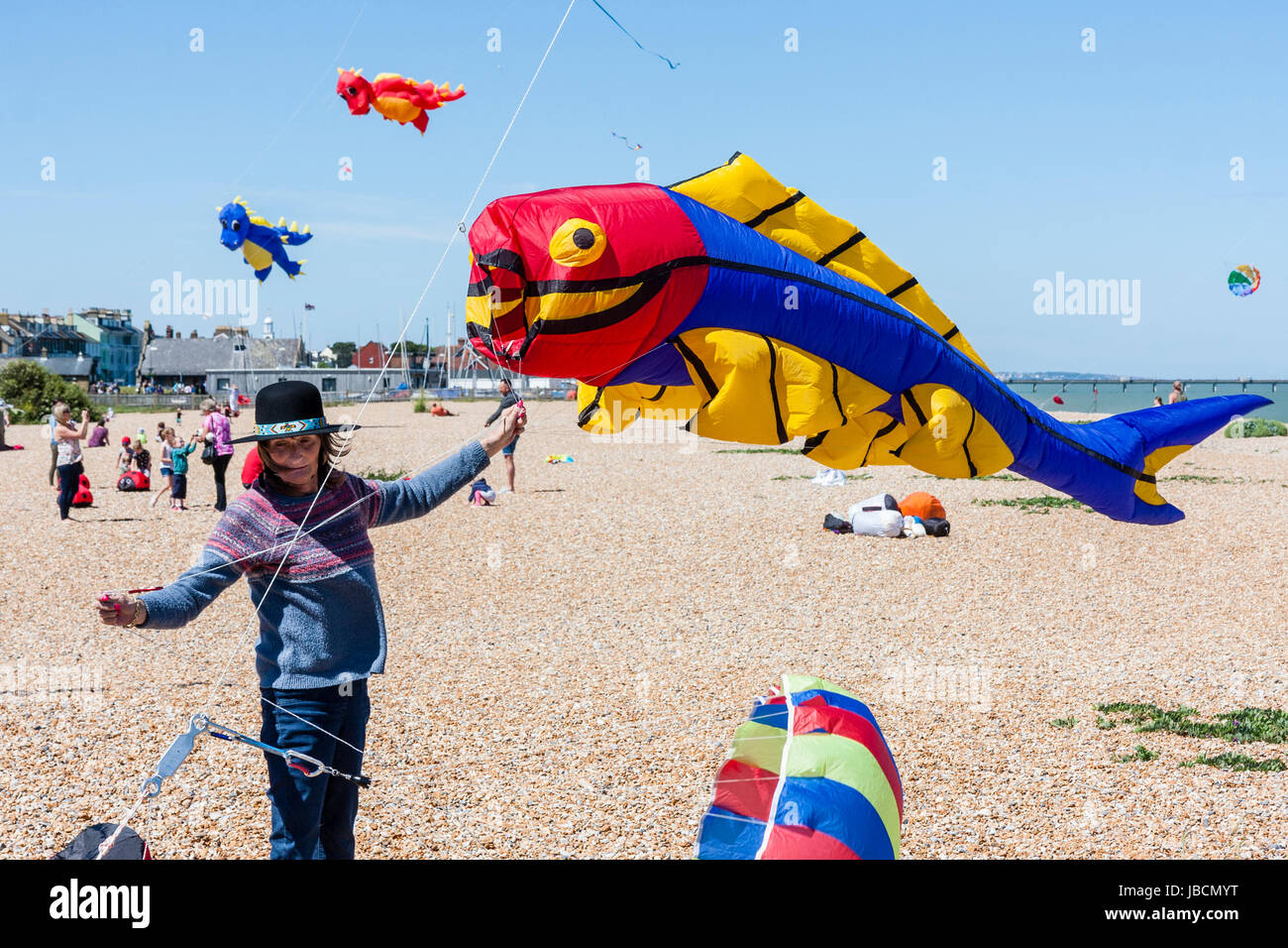 Man on stoney beach at Walmer, in Kent, England, holding a large fish ...