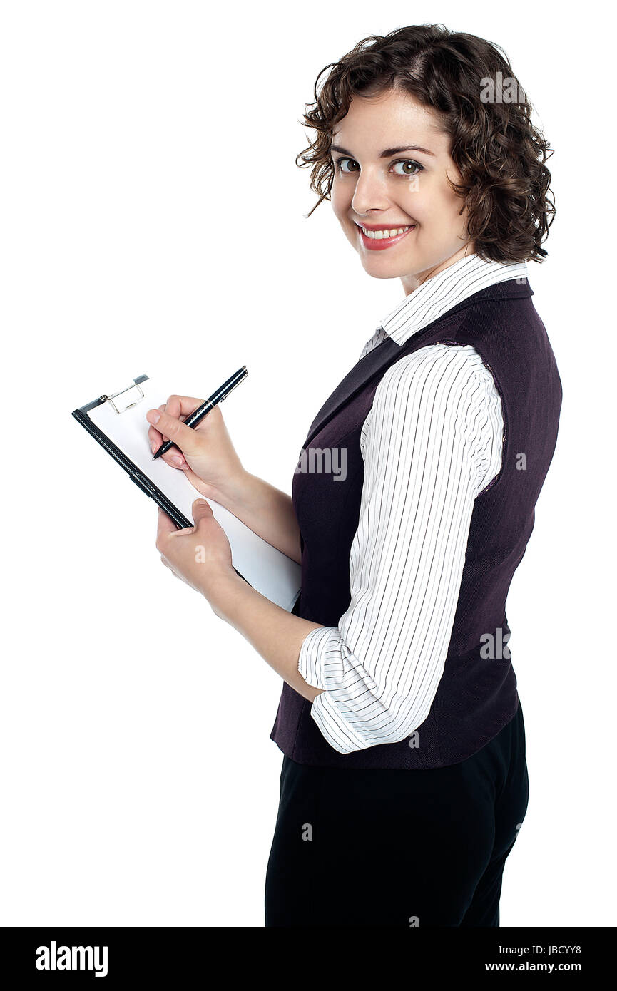 Elegant young executive woman writing down notes on clipboard Stock ...