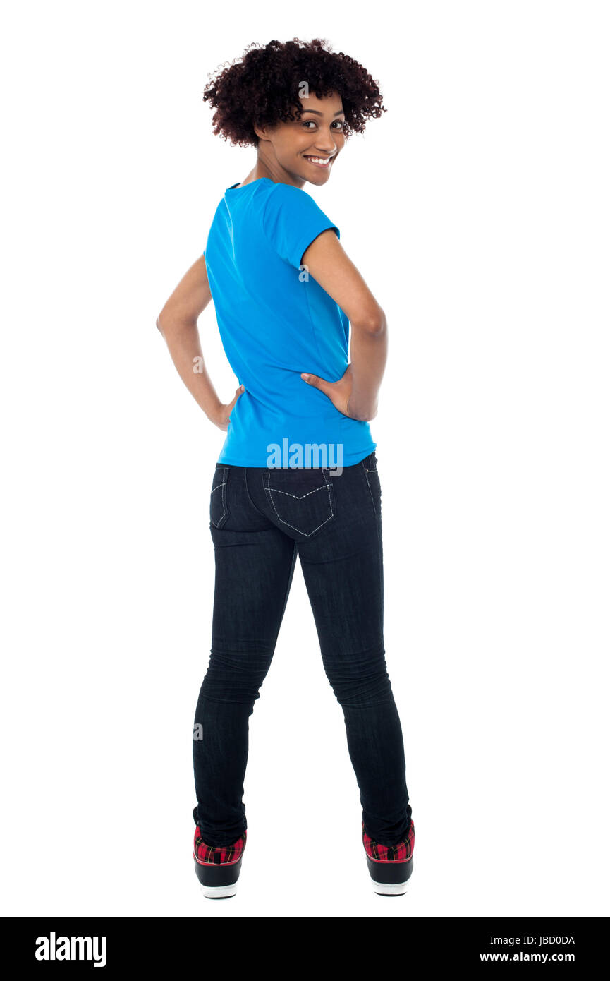 Attractive young lady on white background turning back and smiling at ...