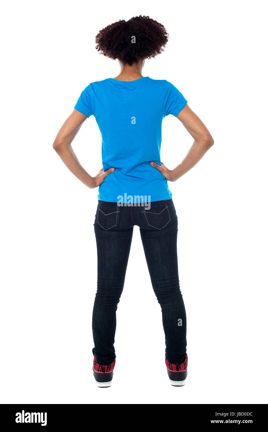 Young curly haired woman posing with hands on waist, facing wall Stock ...