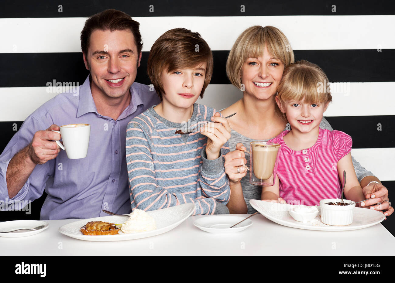 Happy family of four enjoying breakfast at a restaurant Stock Photo - Alamy