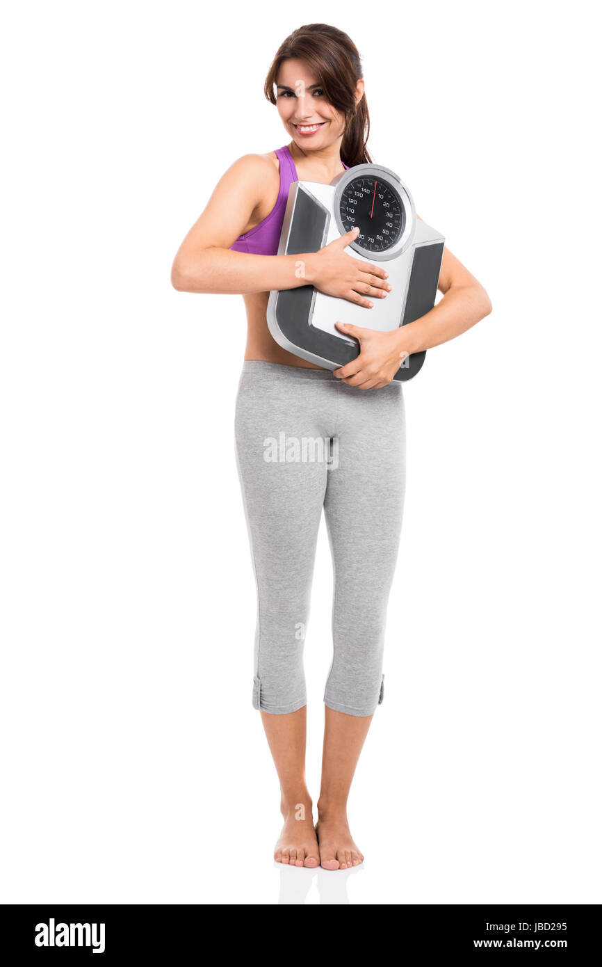 Beautiful athletic woman smilling and holding a scale, isolated on ...