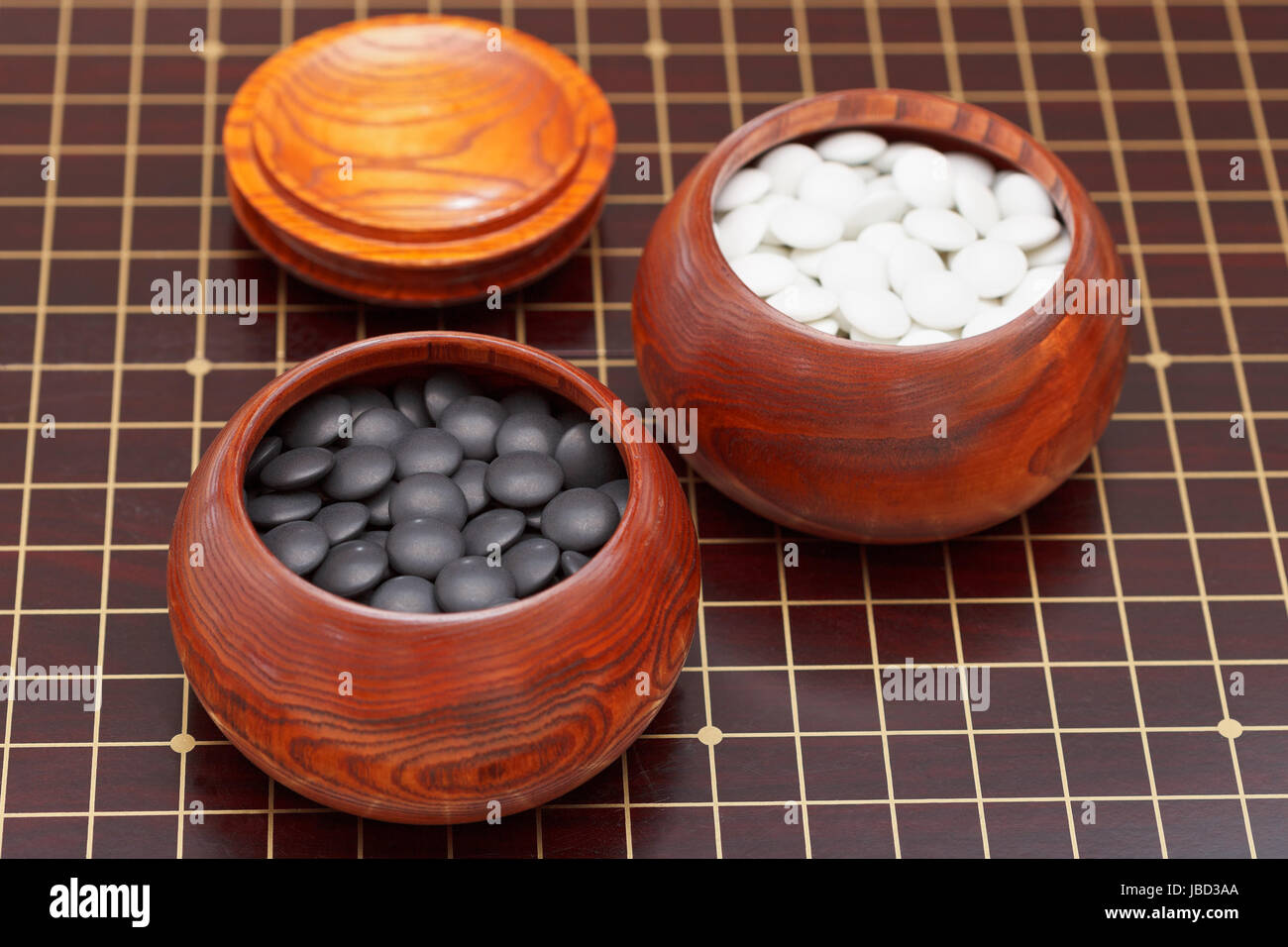 black and white go game stones in wooden bowl Stock Photo - Alamy