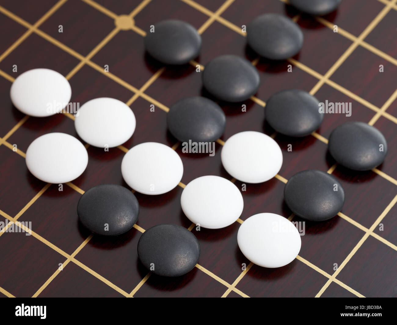 above view of stones during go game playing on wooden goban Stock Photo ...