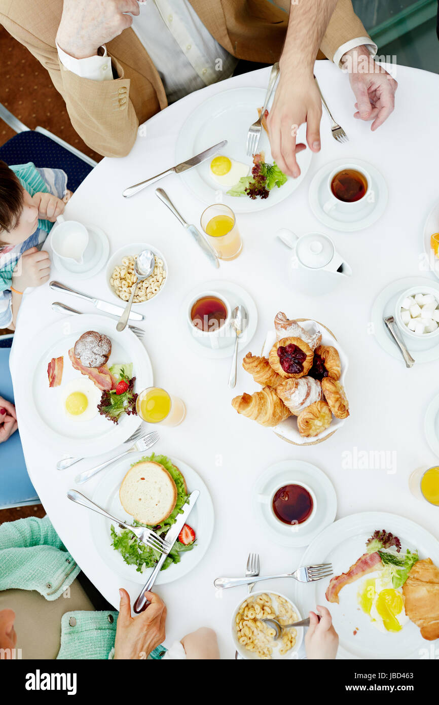 Above view of served table and hands of humans around it Stock Photo ...