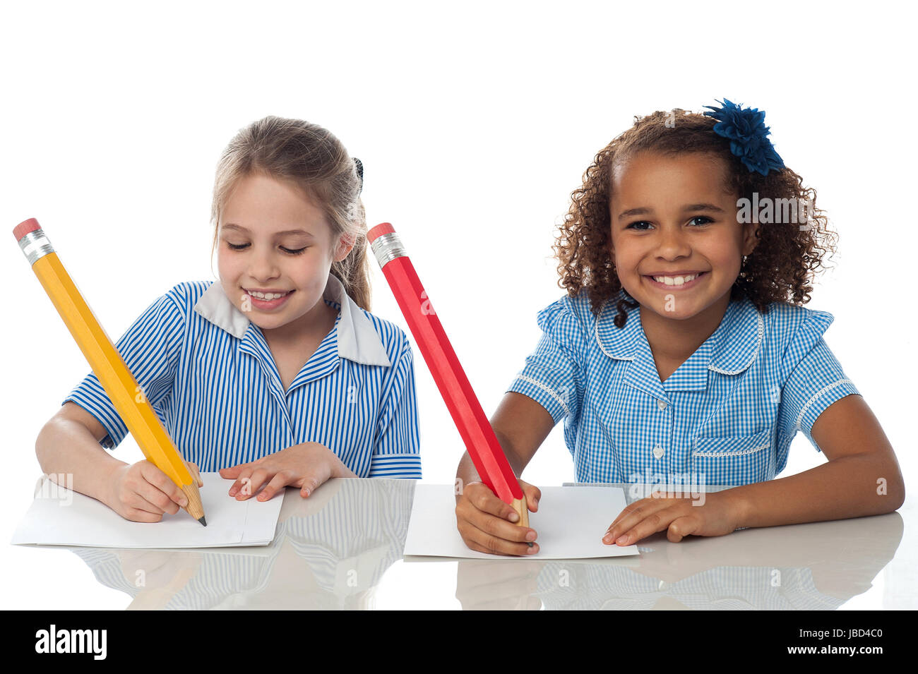 Smiling kids writing their annual exam Stock Photo - Alamy