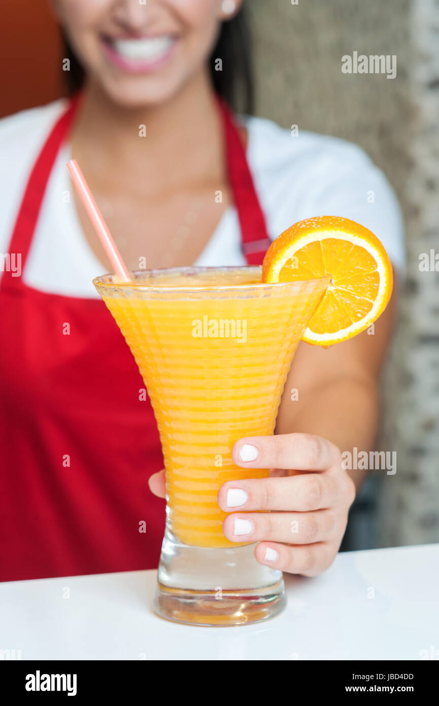 Smiling female chef serving fresh orange juice Stock Photo - Alamy