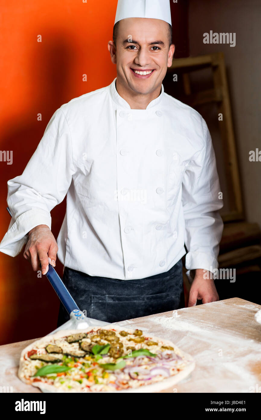 Chef trying to take outthe pizza Stock Photo - Alamy