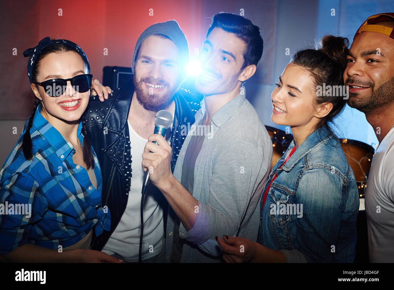 Group of smiling party people, men and women, having fun on stage ...