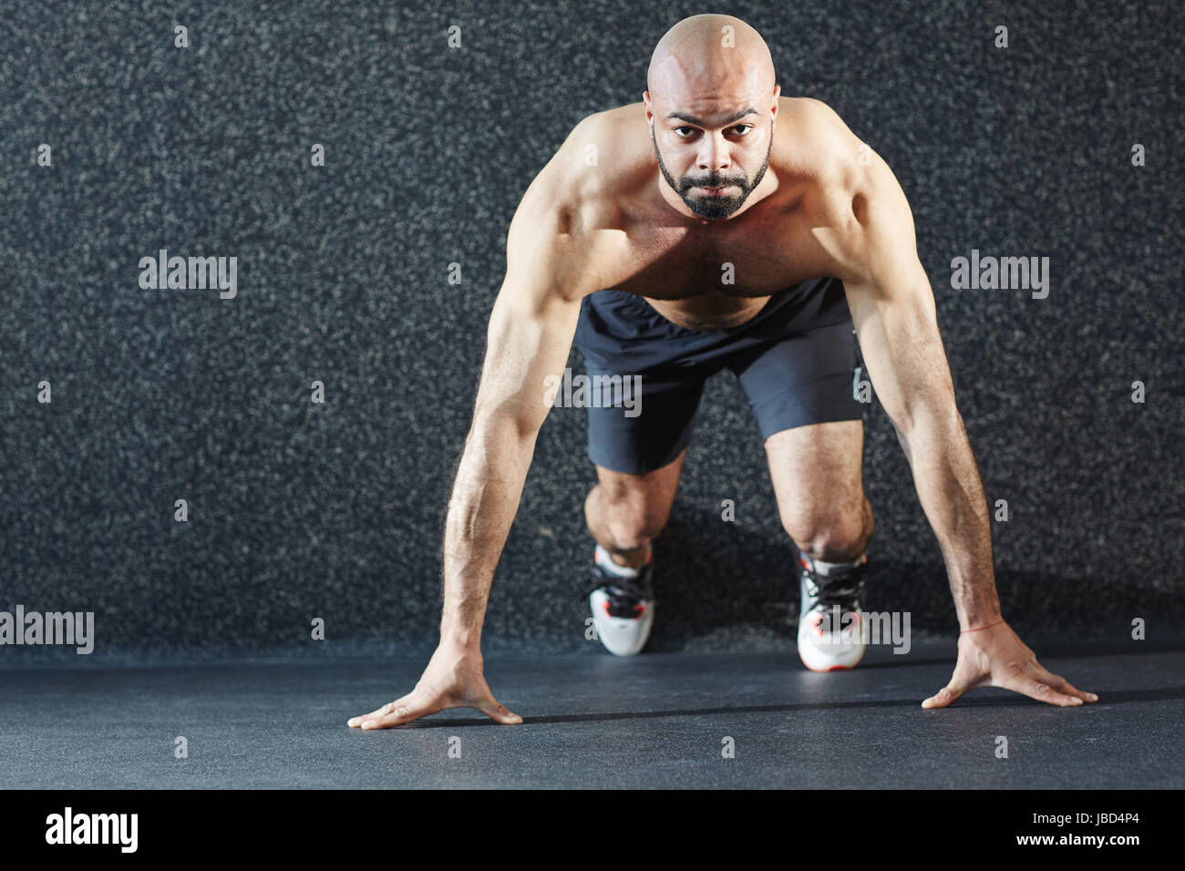 Motivational portrait of shirtless muscular man standing in start ...