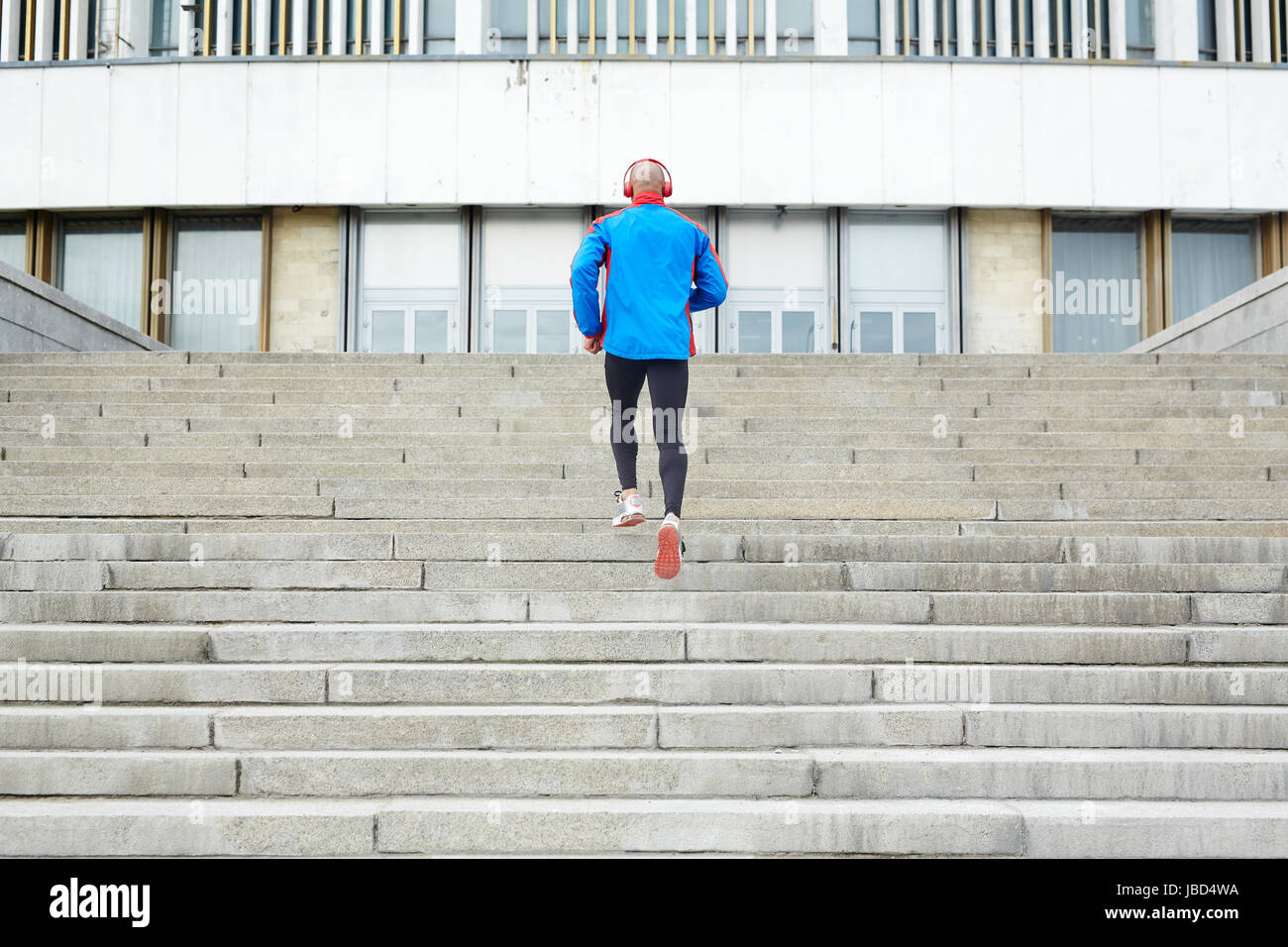 Young man running upstairs in urban environment Stock Photo - Alamy